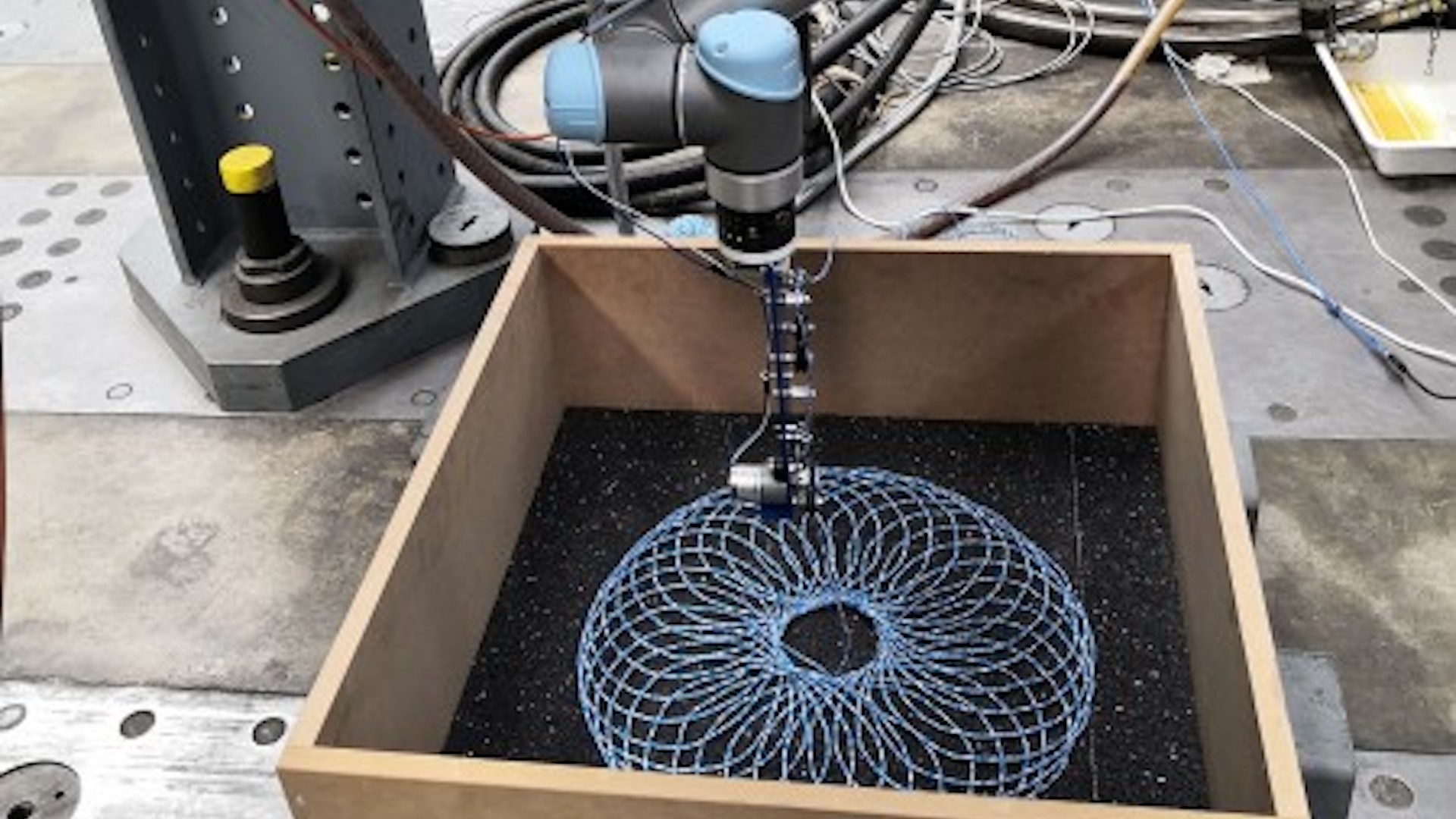 Robotic Arms Build Roads by Binding Asphalt with Strings